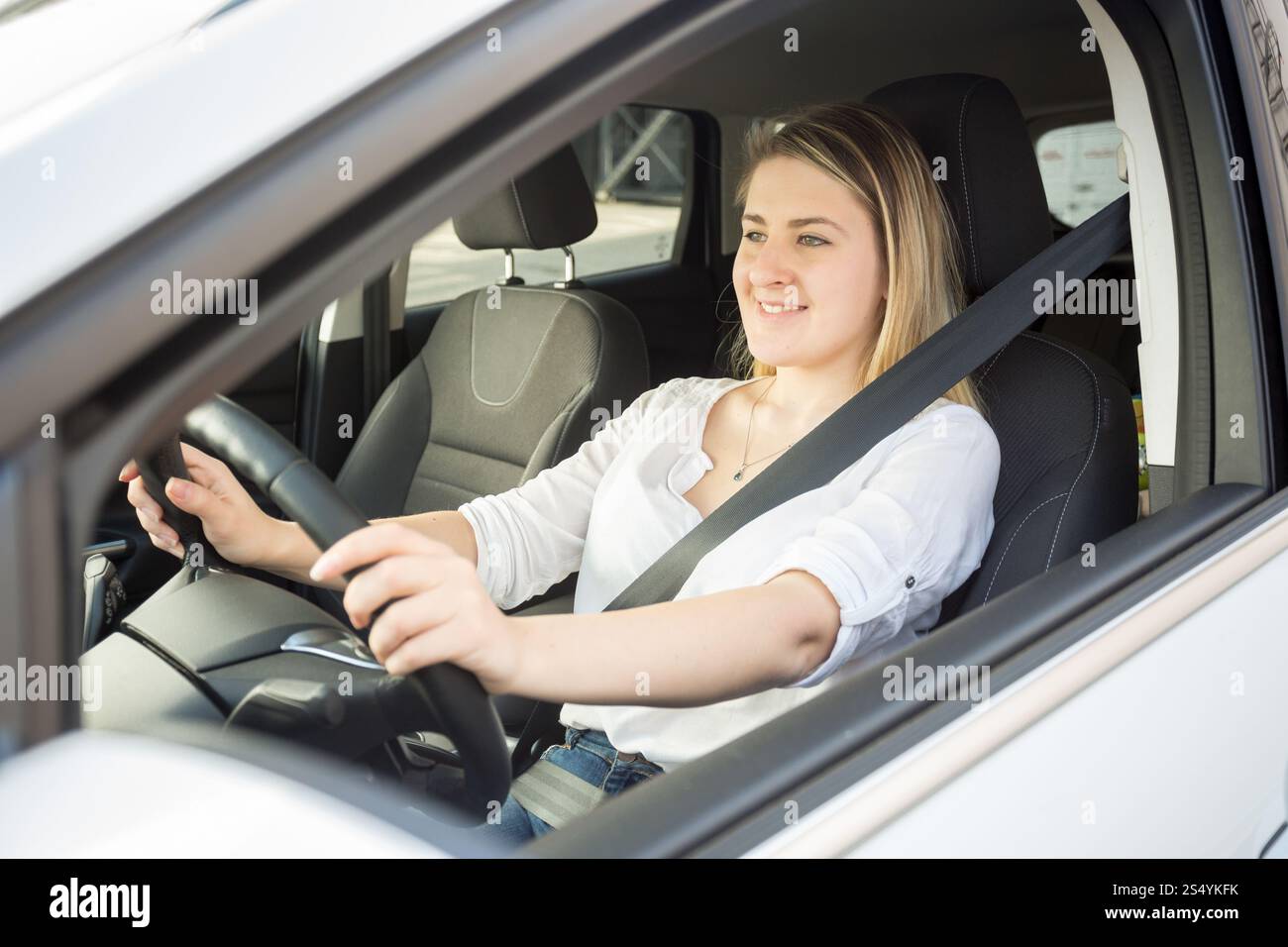 Portrait of smiling woman driving car and looking at camera Stock Photo ...