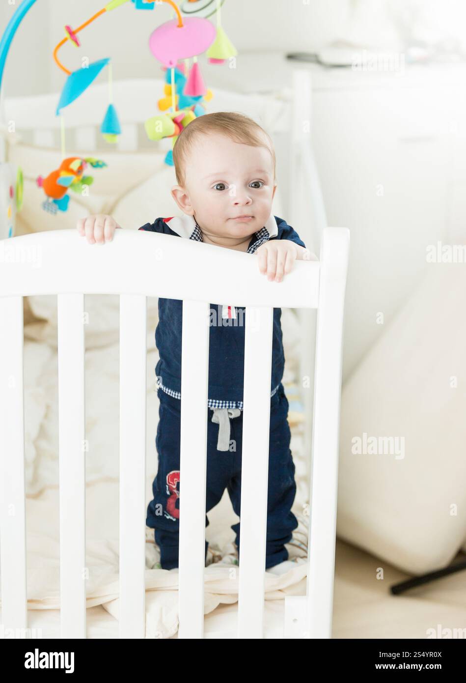 Cute 9 month old baby boy standing in crib Stock Photo - Alamy