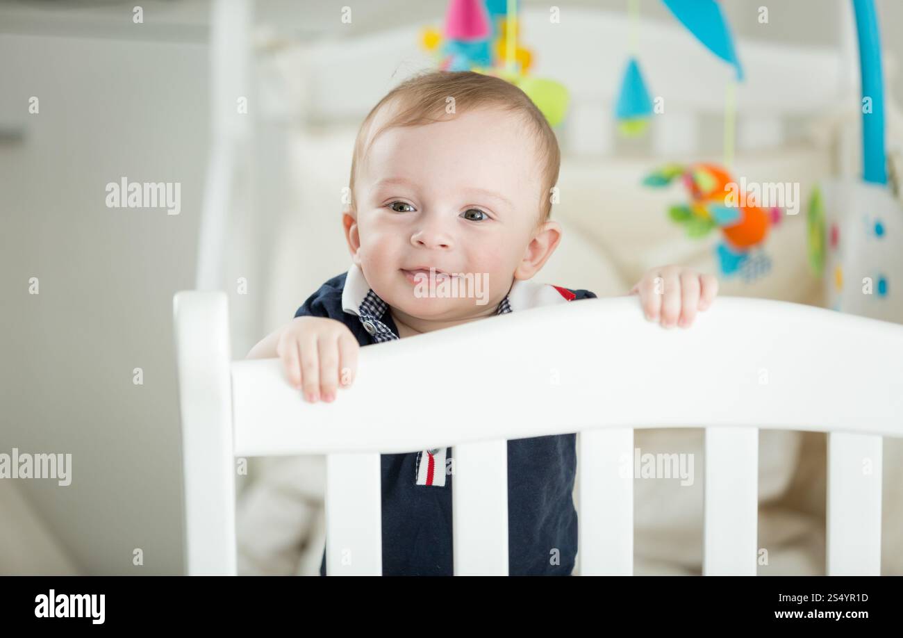 Cute 9 month old baby boy standing crib Stock Photo - Alamy