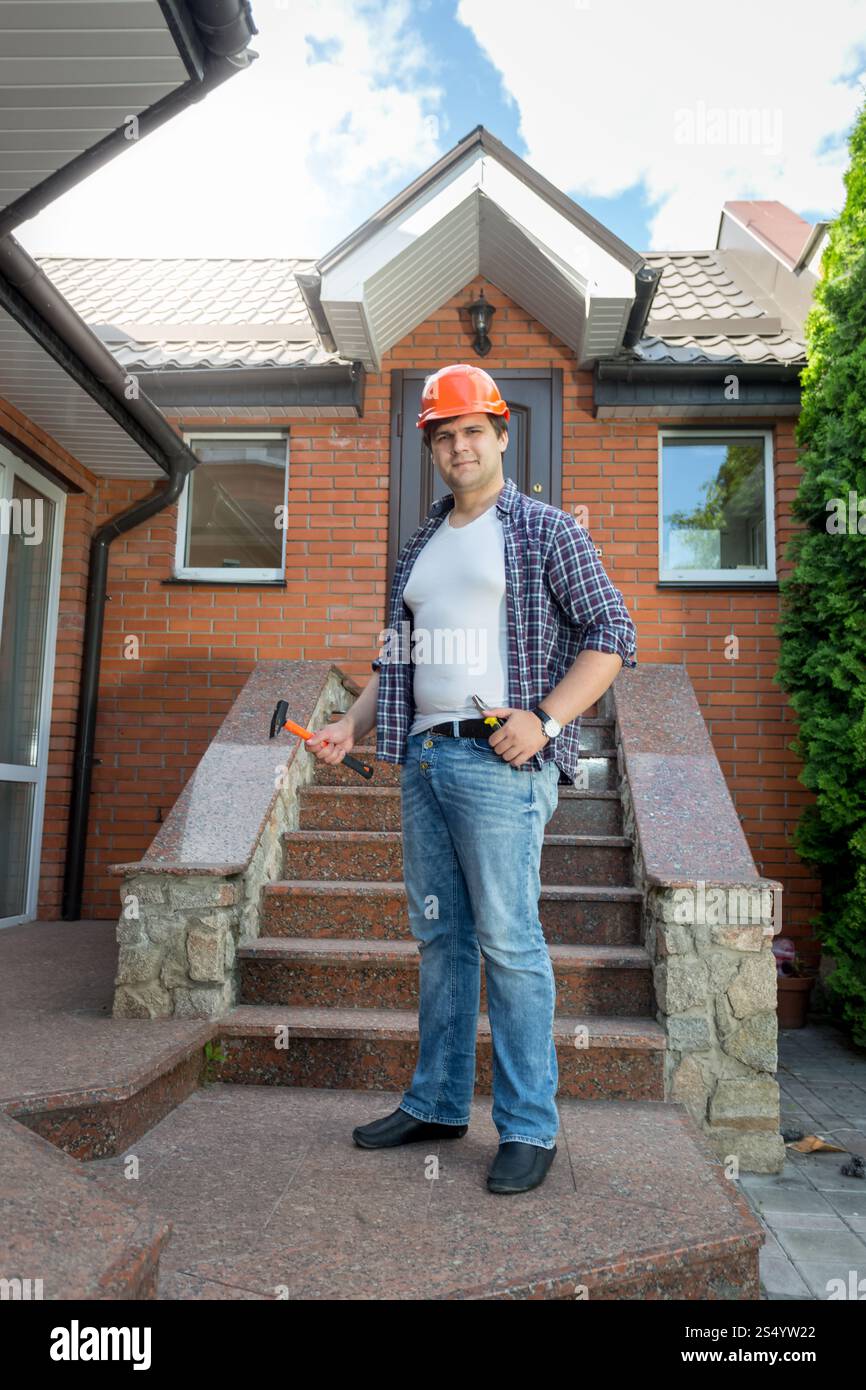 Smiling worker posing in front of house with stone staircase Stock ...