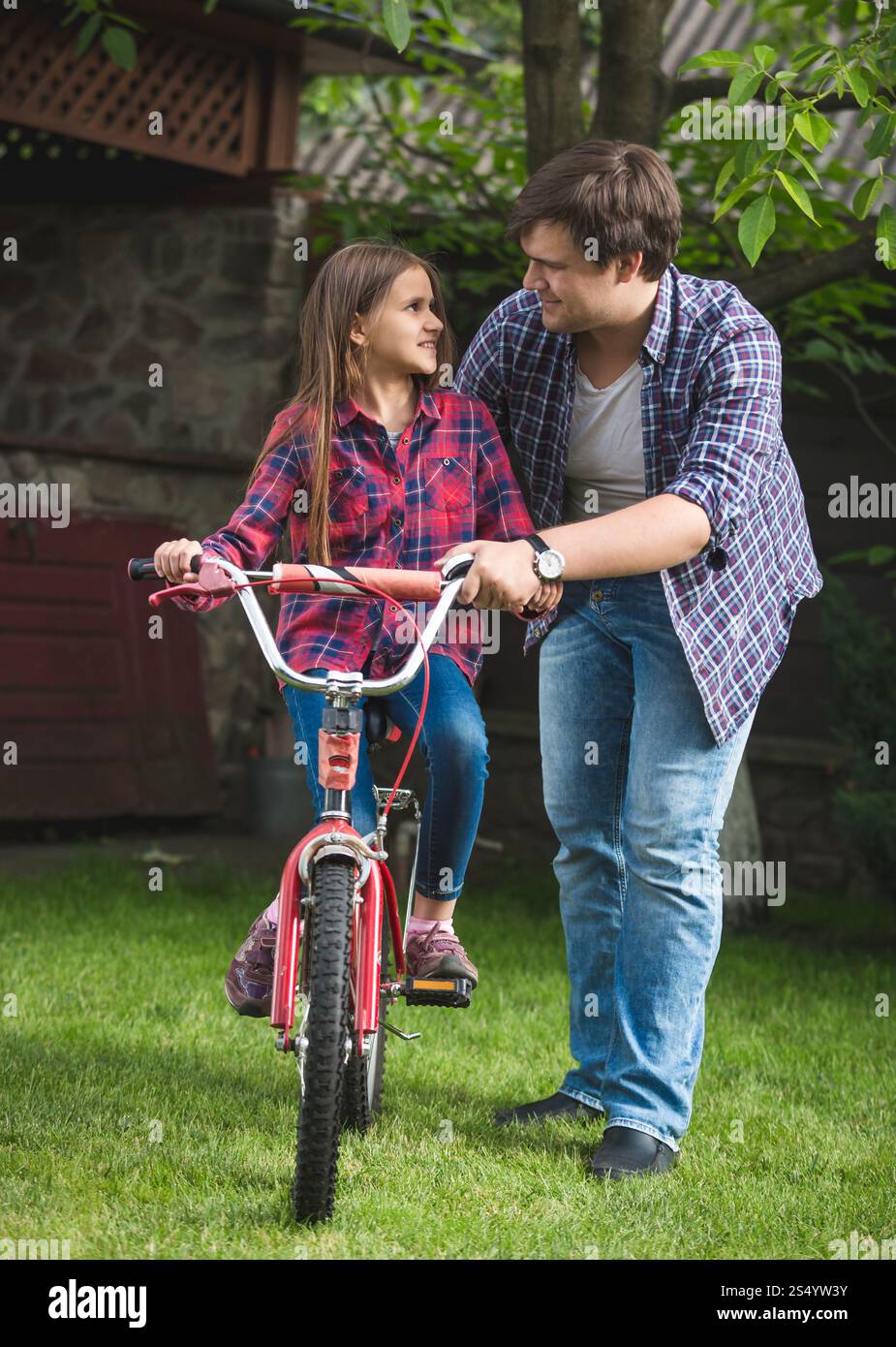 Man teaching a girl to ride a bike hi-res stock photography and images ...