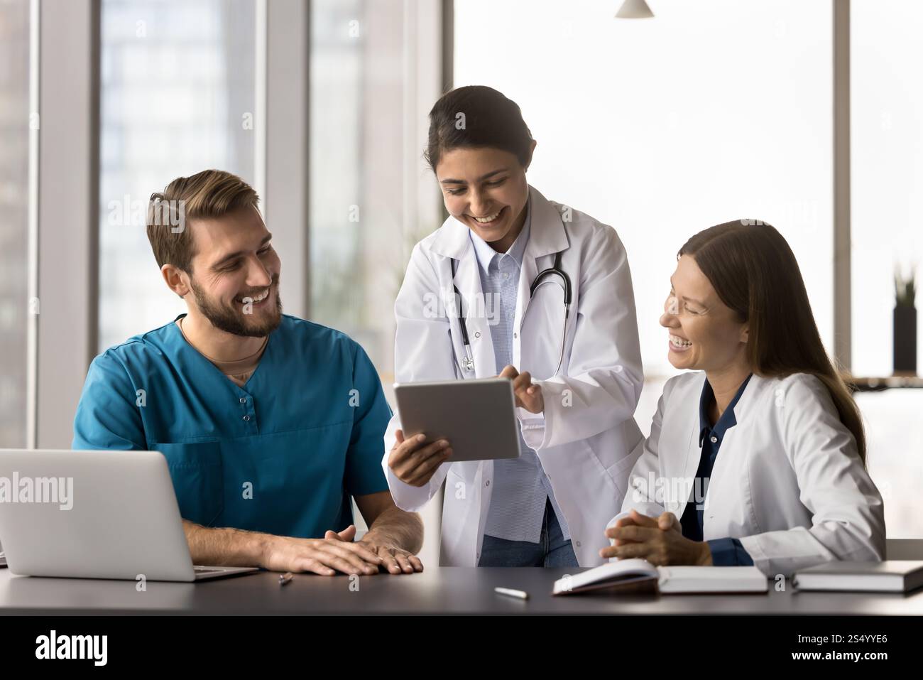 Laughing multiethnic medical workers using modern digital tablet Stock ...