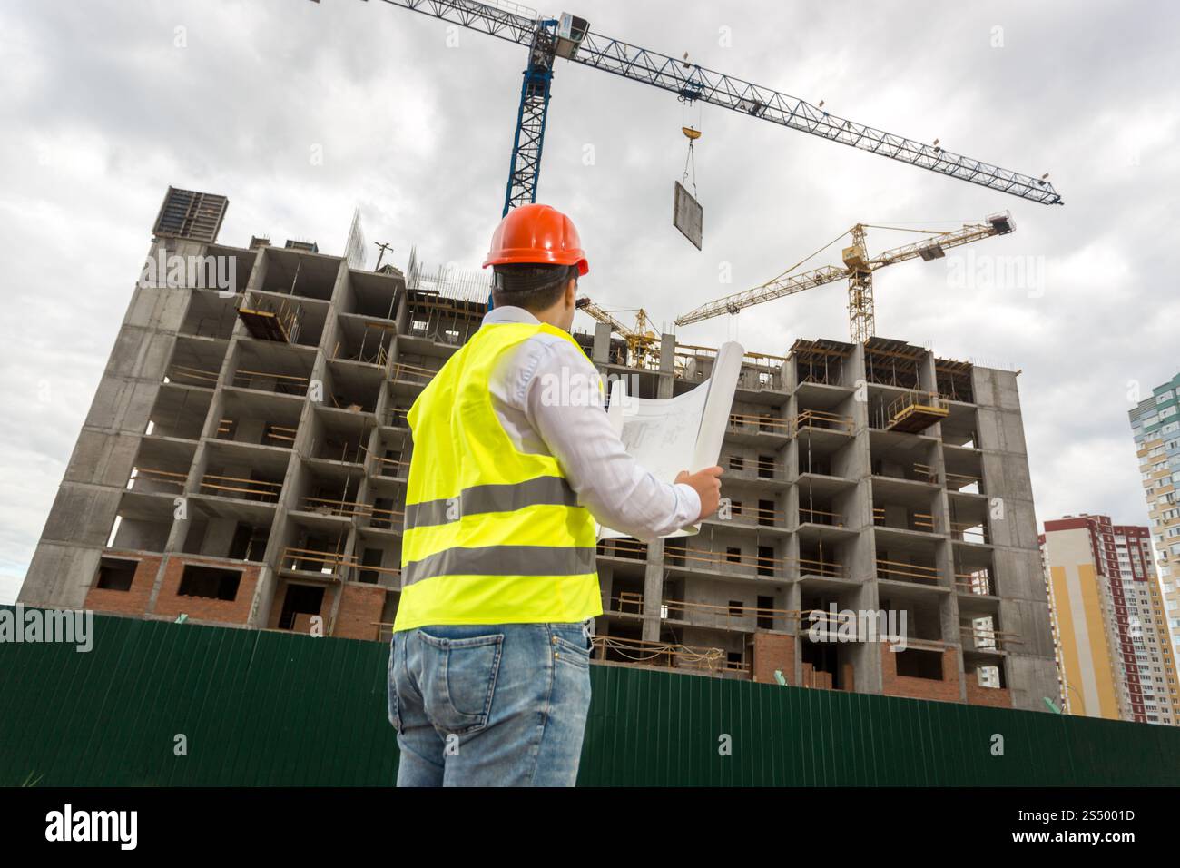 Young engineer inspector looking at building under construction Stock ...