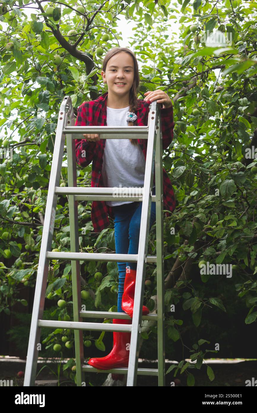 Happy teenage girl posing on stepladder at apple garden Stock Photo - Alamy
