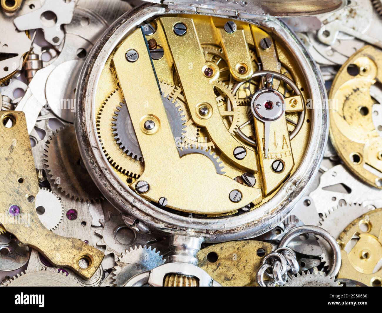watchmaker workshop - open old brass mechanical pocket watch on pile of ...