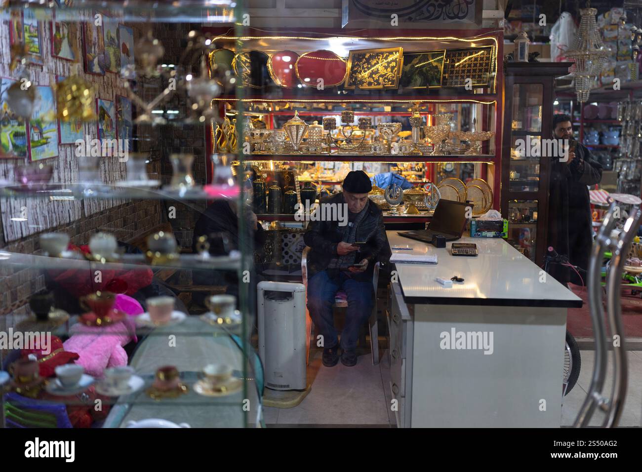 A shop owner waits for customers in a souvenirs shop in Idlib, Syria ...