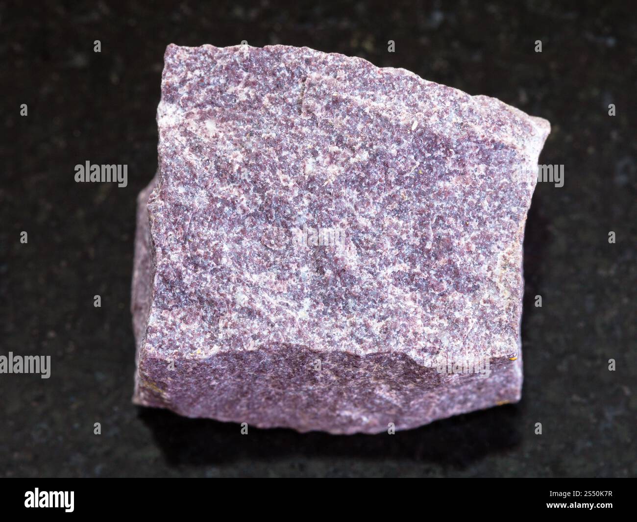 macro shooting of natural mineral rock specimen - rough Alunite stone on dark granite background ...