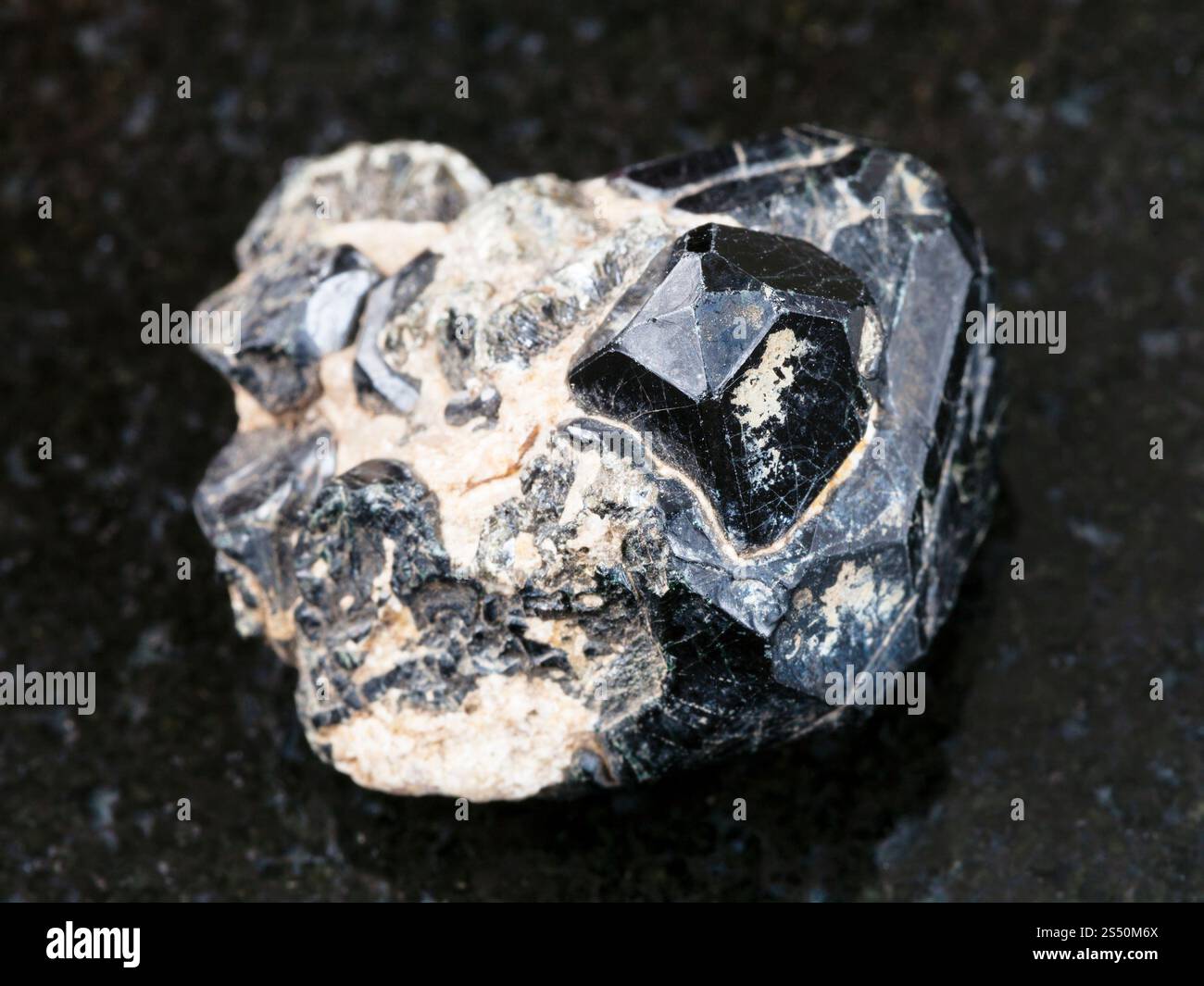 macro shooting of natural mineral rock specimen - black crystal of ...
