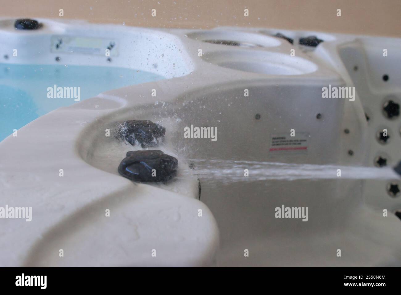 Valve regulator of a light grey Swim Spa pool being cleaned with a ...