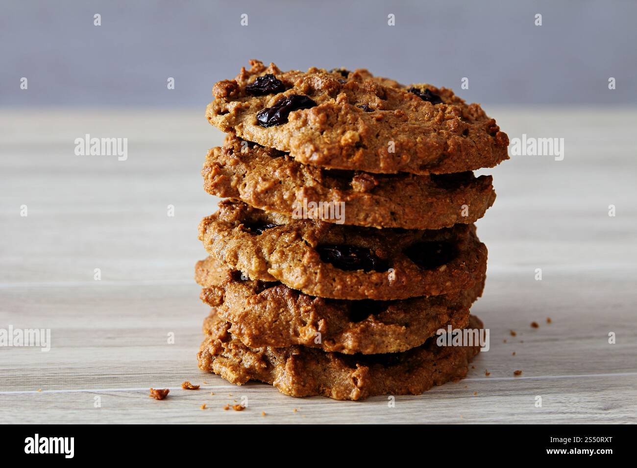 Oatmeal raisin cookies stacked on a kitchen counter with crumbs Stock ...