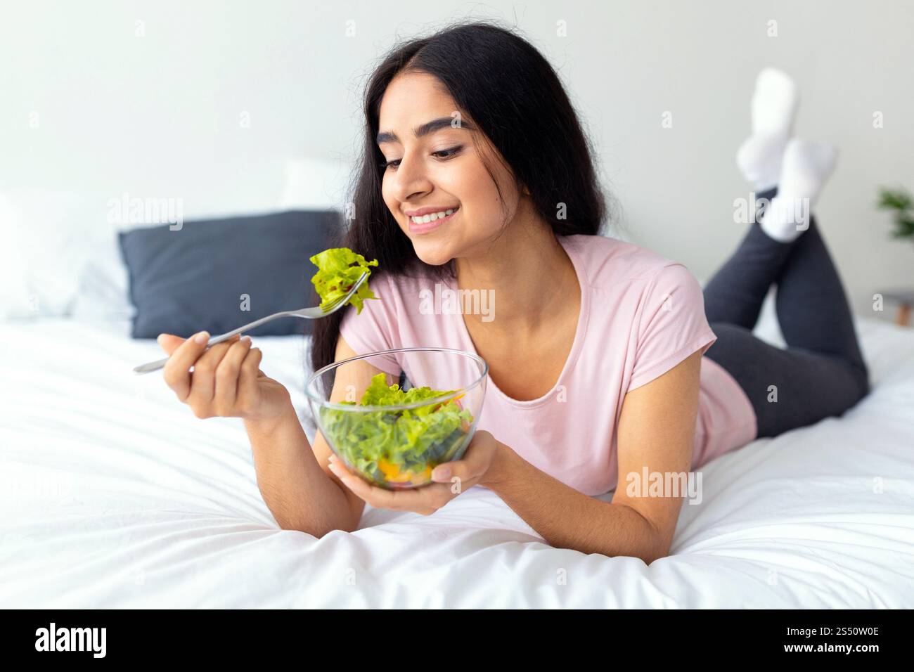 Balanced raw food diet. Lovely Indian woman eating fresh vegetable ...