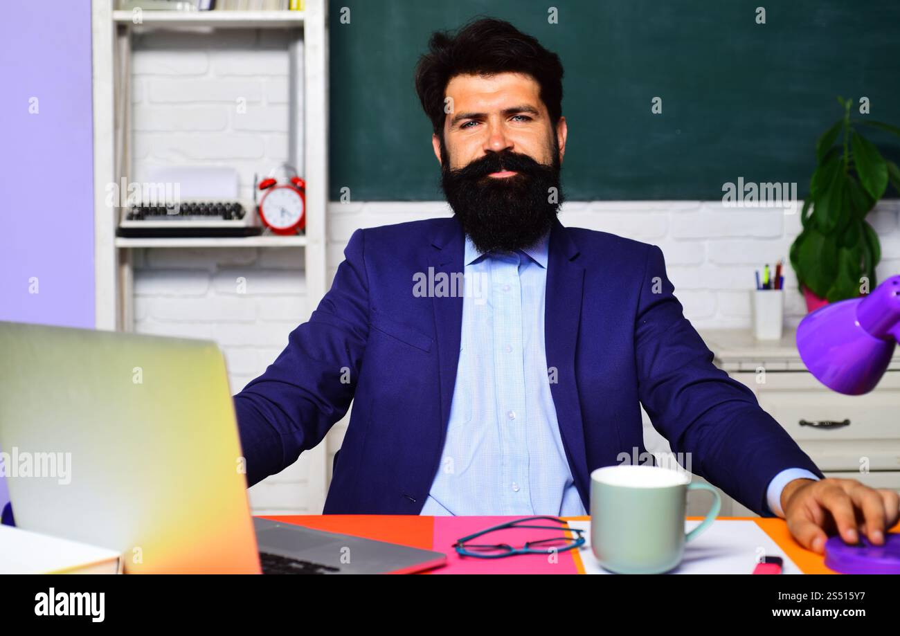 School teacher or university professor sitting at desk in classroom ...