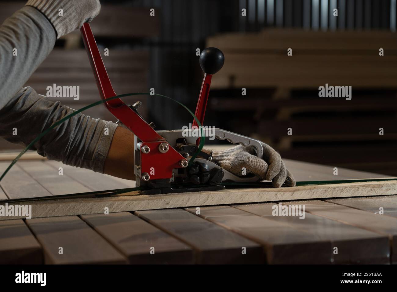 A strapping tool on a workbench secures packing tape. Focus on the tool ...