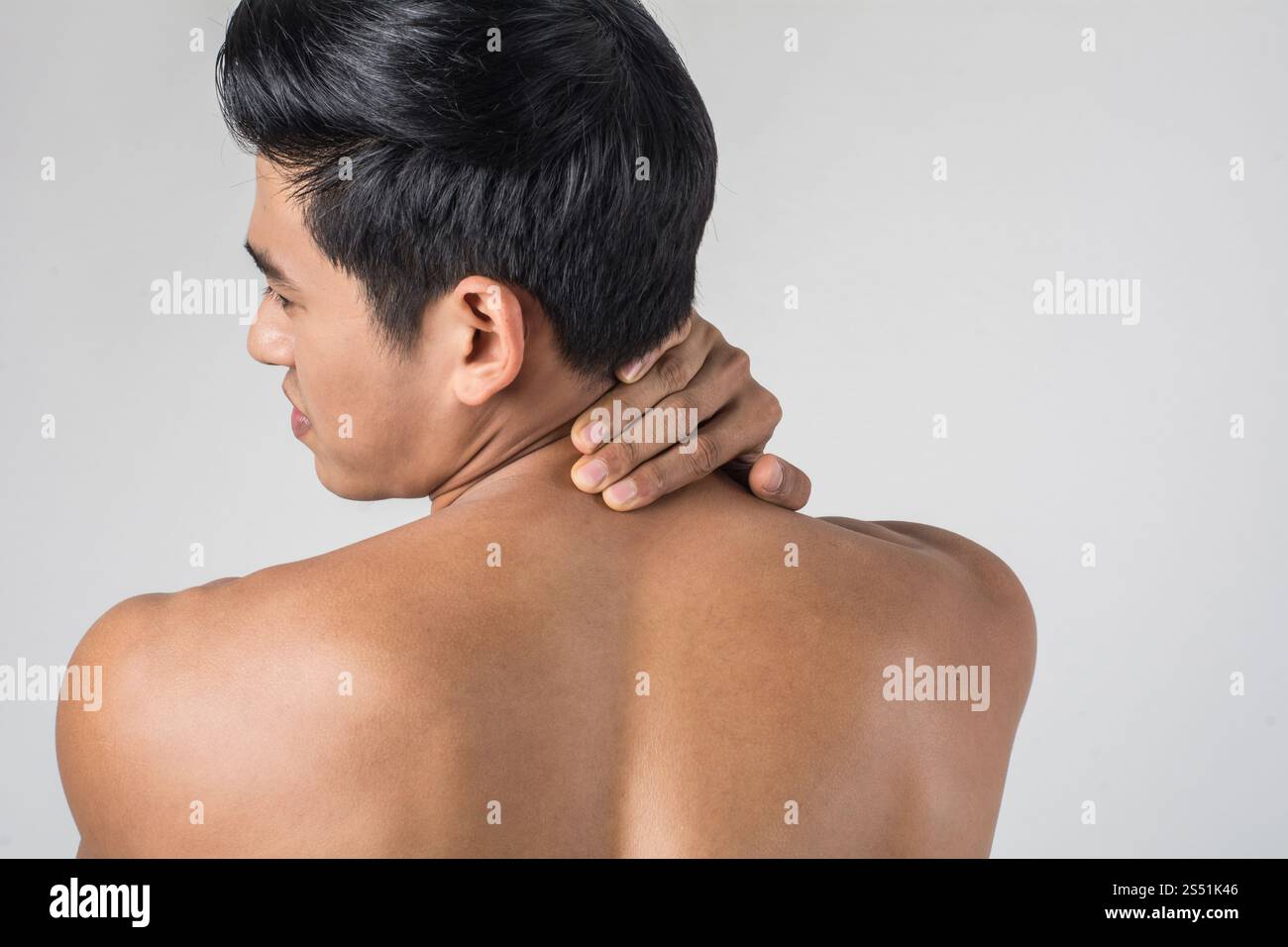 Muscular man use handles at the neck to relieve pain isolated on white ...