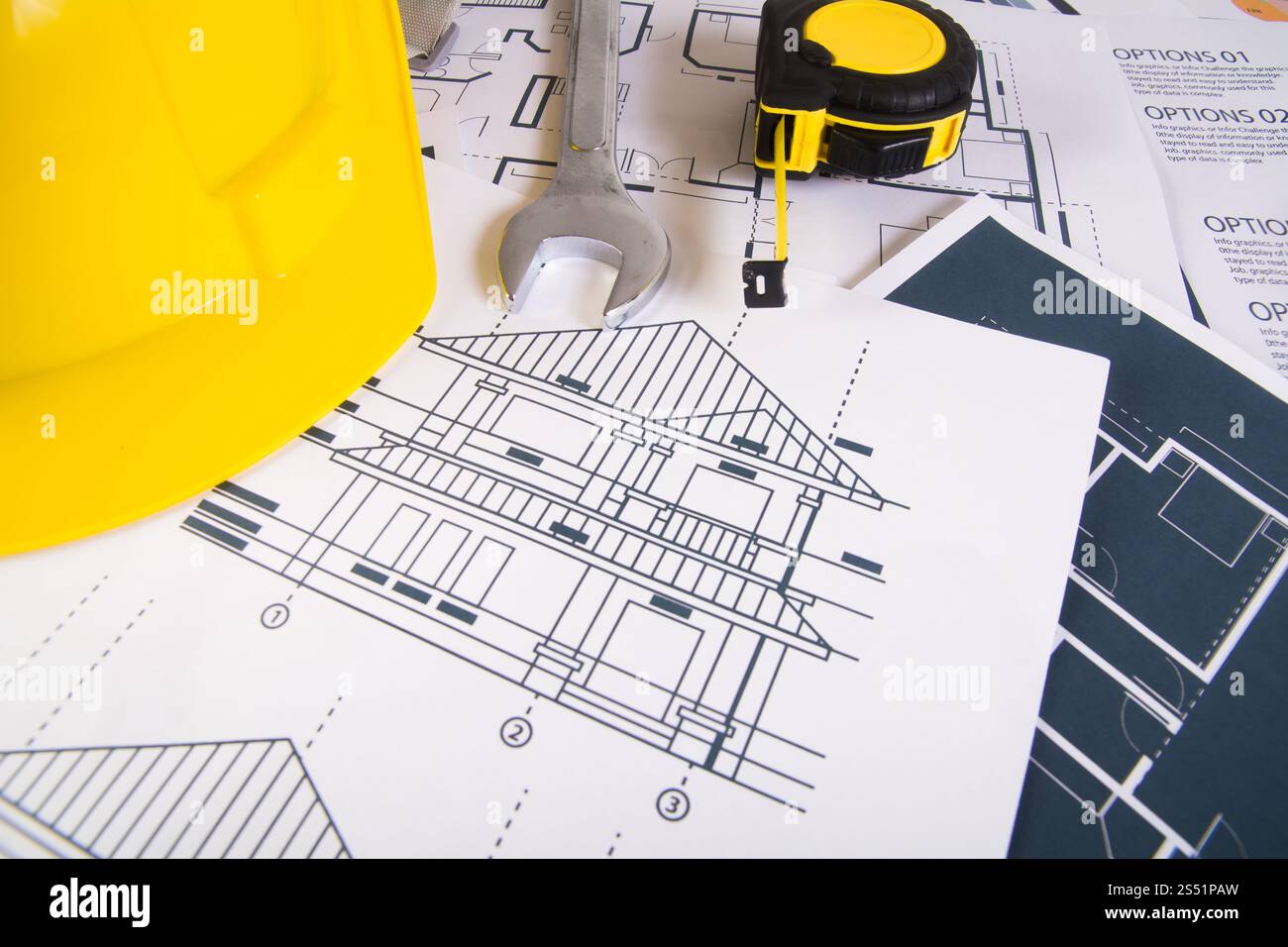 Engineer workplace with blueprints, protractor and safety helmet ...