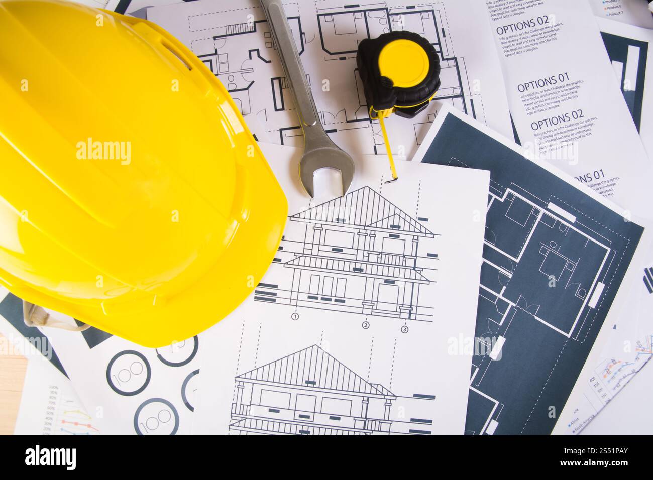 Engineer workplace with blueprints, protractor and safety helmet ...