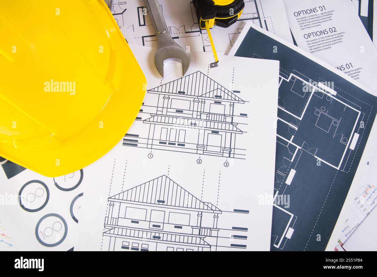 Engineer workplace with blueprints, protractor and safety helmet ...