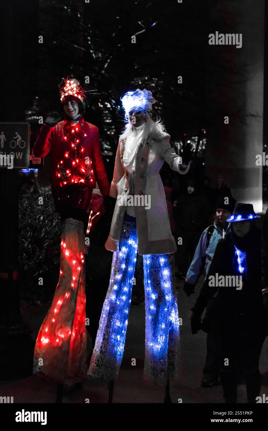 Two Performers on Stilts with Colorful Lights at Nighttime Festival ...