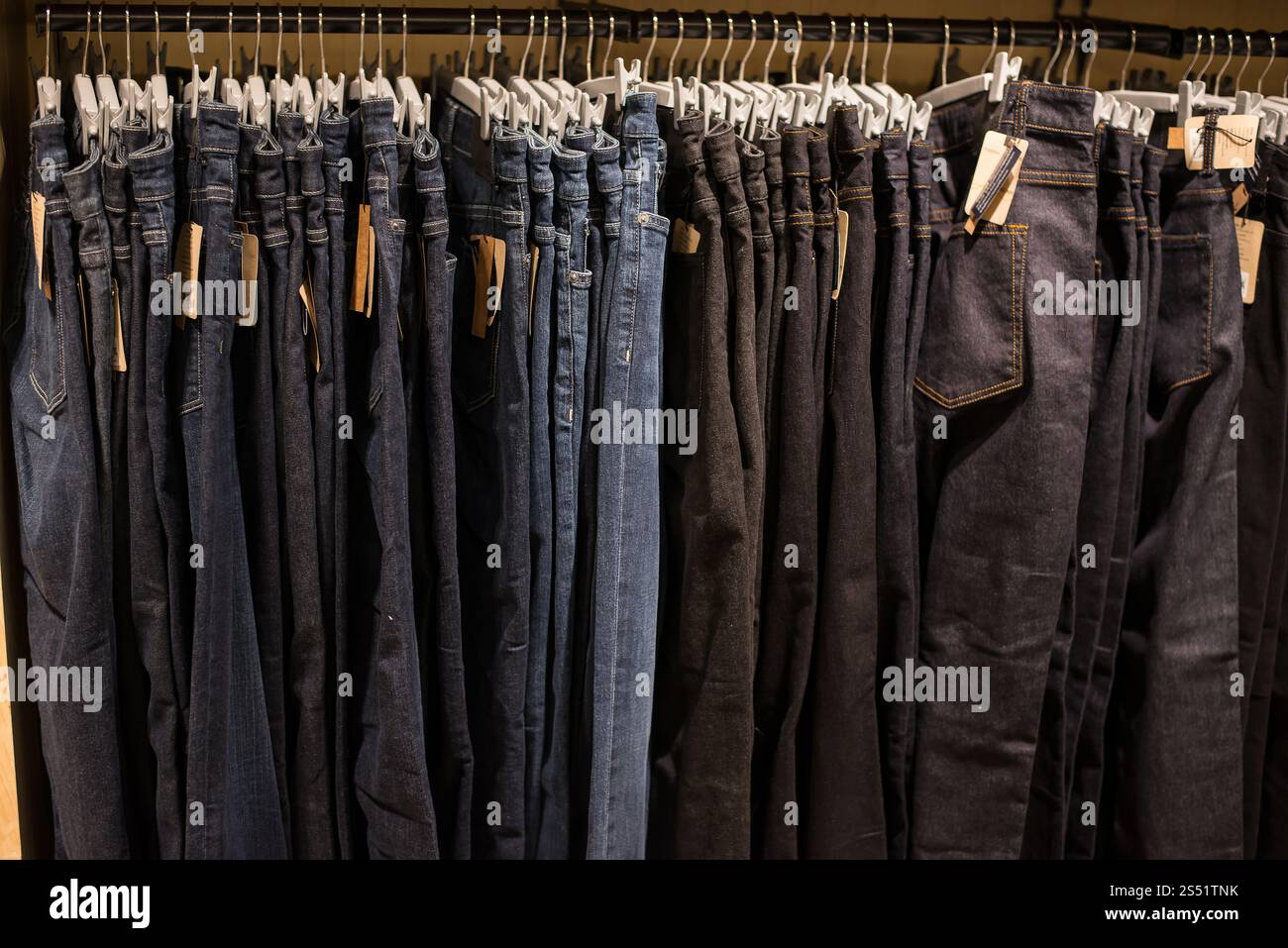 Jeans on clothes rail in clothing store at shopping mall Stock Photo ...