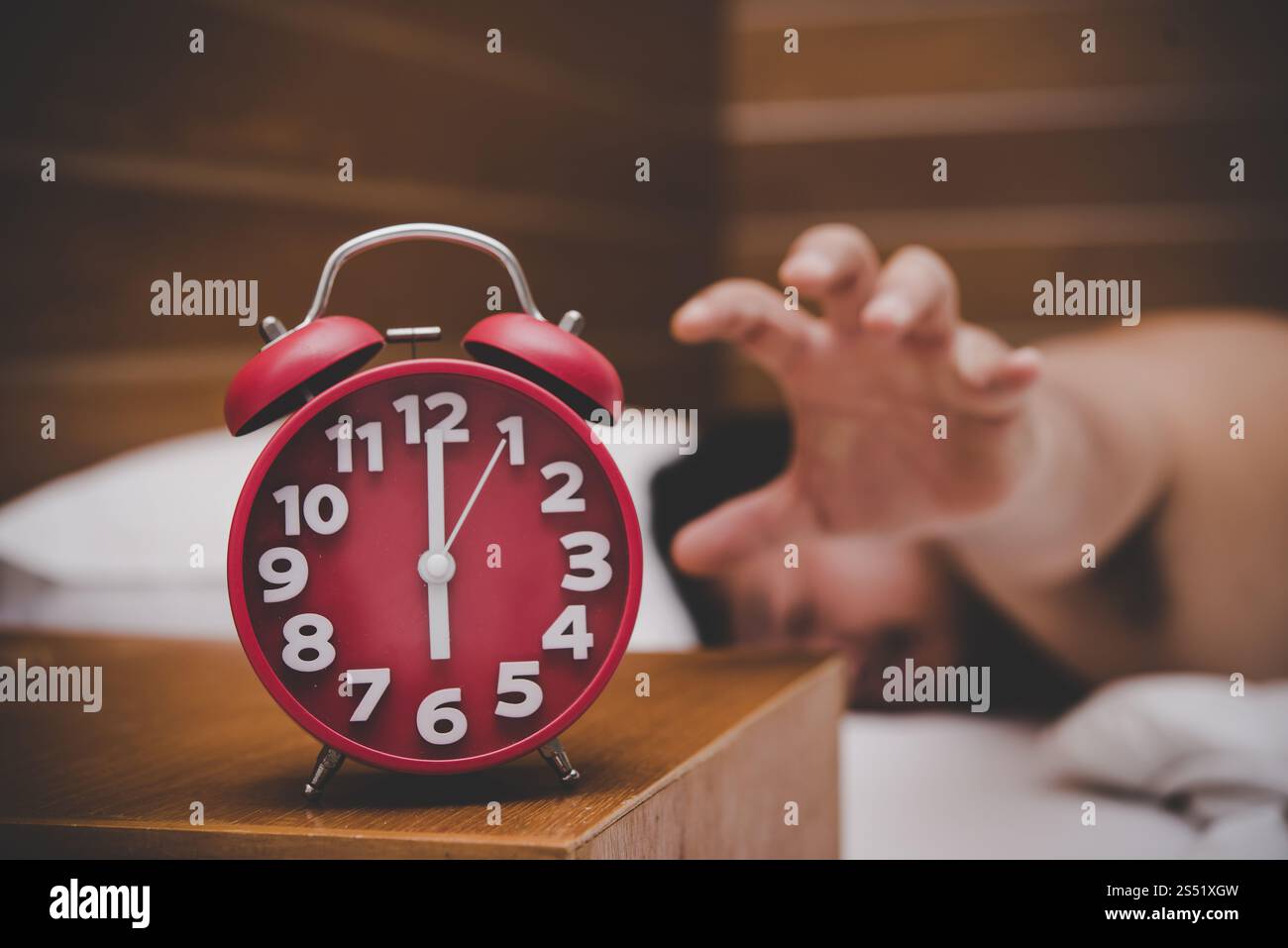 Man being awakened by an alarm clock in his bedroom Stock Photo - Alamy