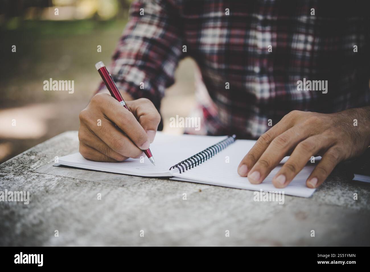 Man hand writing on his notebook Stock Photo - Alamy