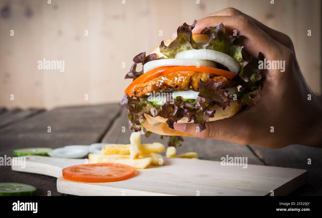 man holds burger with hands and potato chip Stock Photo - Alamy