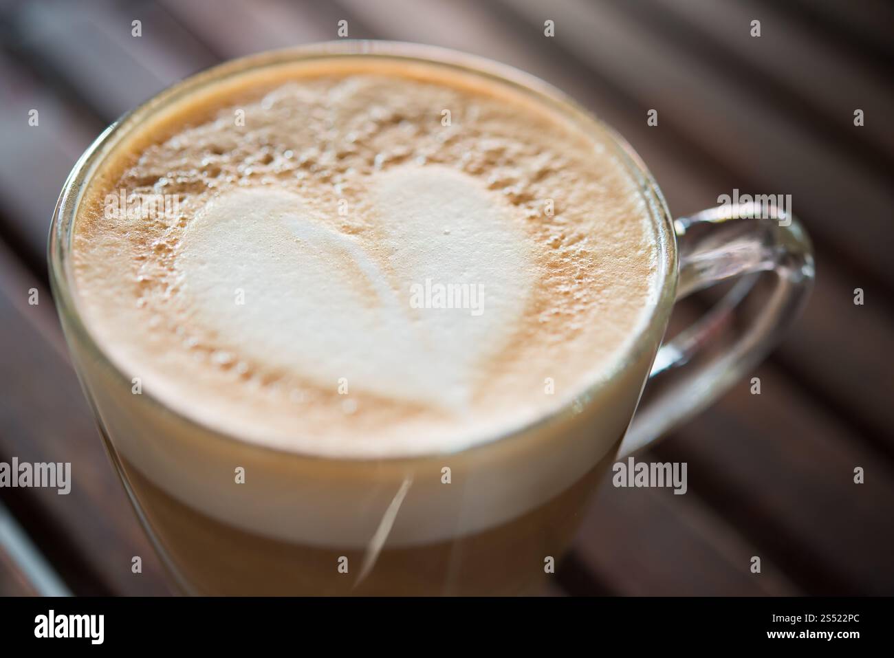 Close up of cappuccino cup with heart shaped milk pattern at caf. Close ...