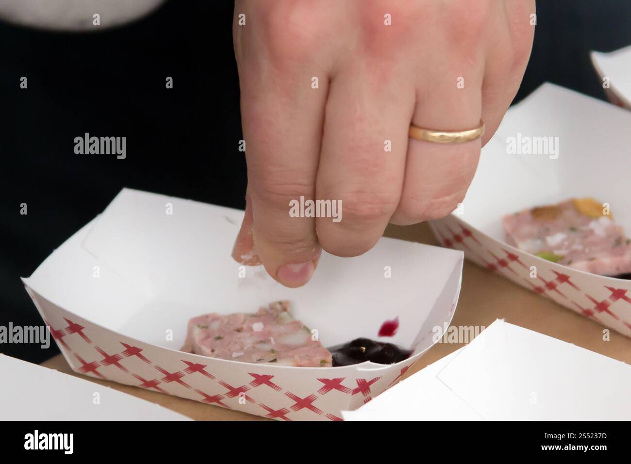 Close-Up of a Hand Plating Food From a Paper Tray Stock Photo - Alamy