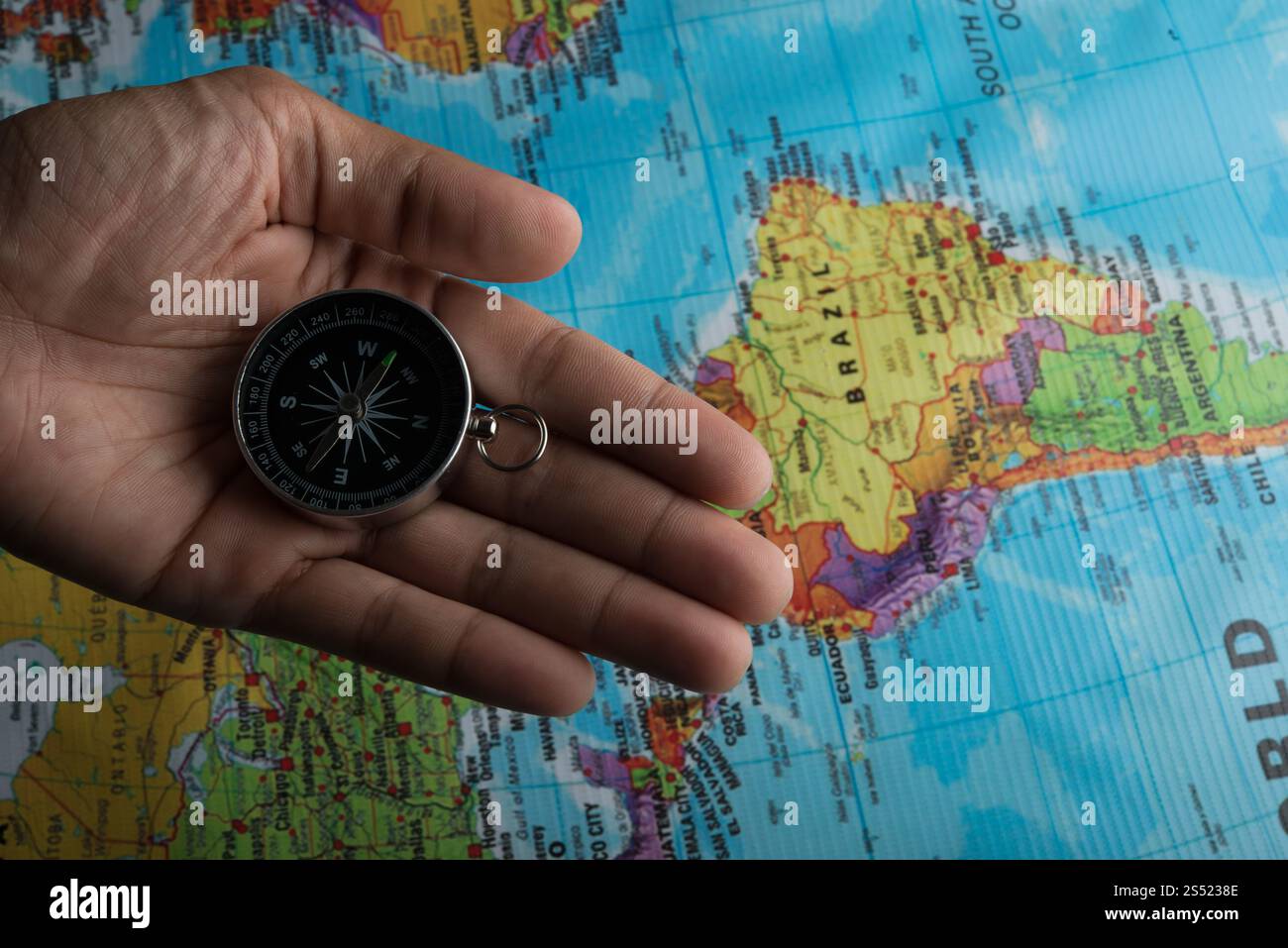 Man hand holding compass on top of a map Stock Photo - Alamy