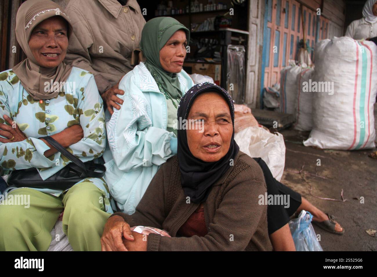 A group of happy Muslim women sitting in an outdoor market in ...