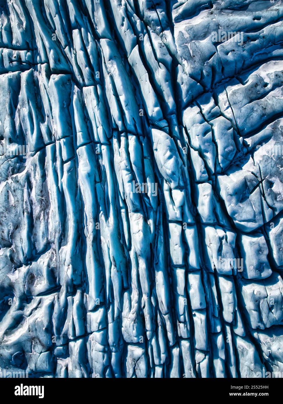 Close-up aerial view of intricate crevasses and lines on a glacier in ...