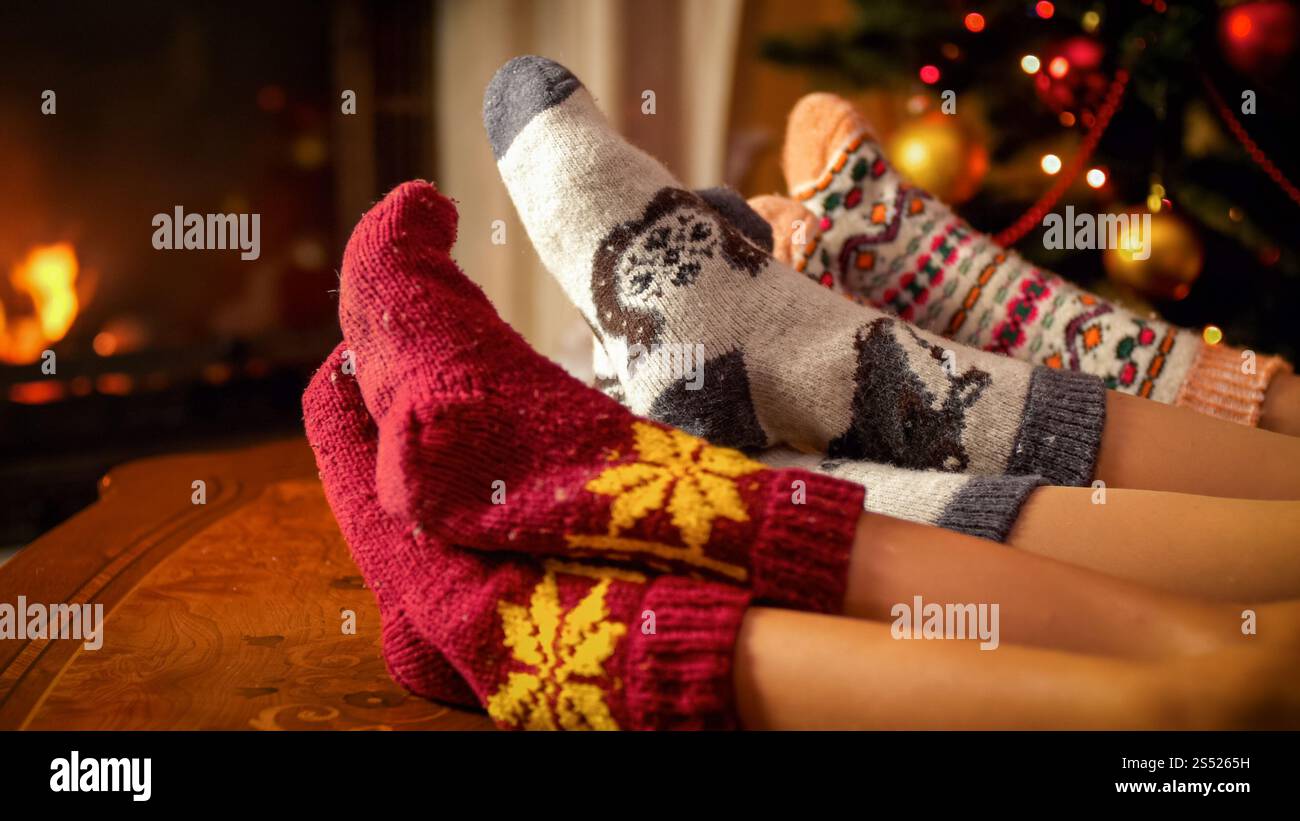Family warming their feet in socks on Christmas eve at burning ...