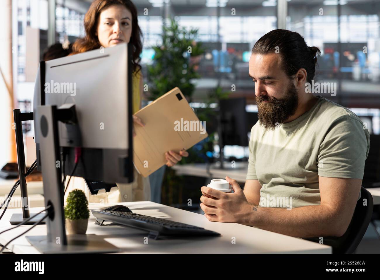 Tired company worker caught falling asleep at desk in office by manager while doing research for ...