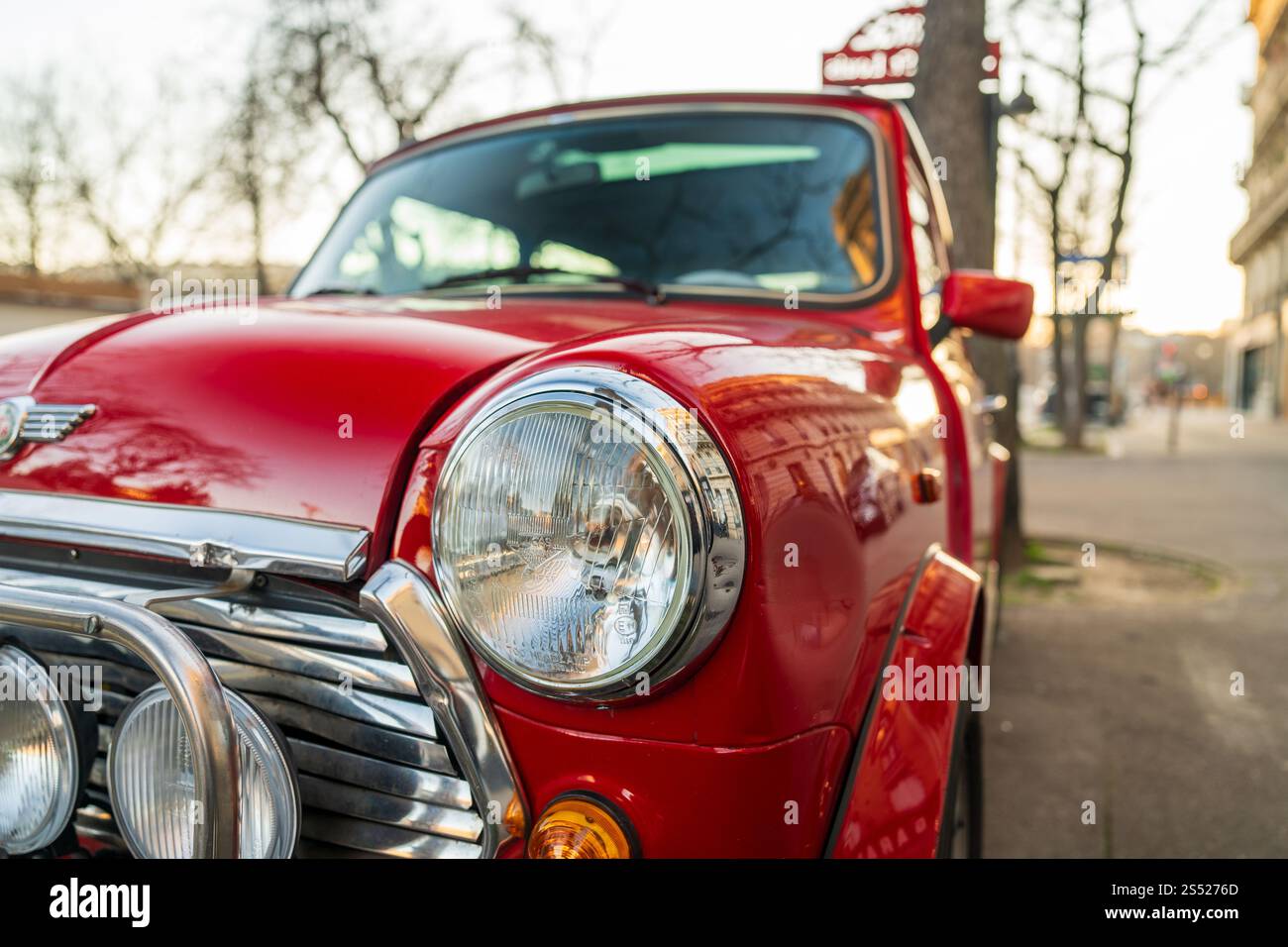 Classic red car parked on city street during golden hour light Stock ...