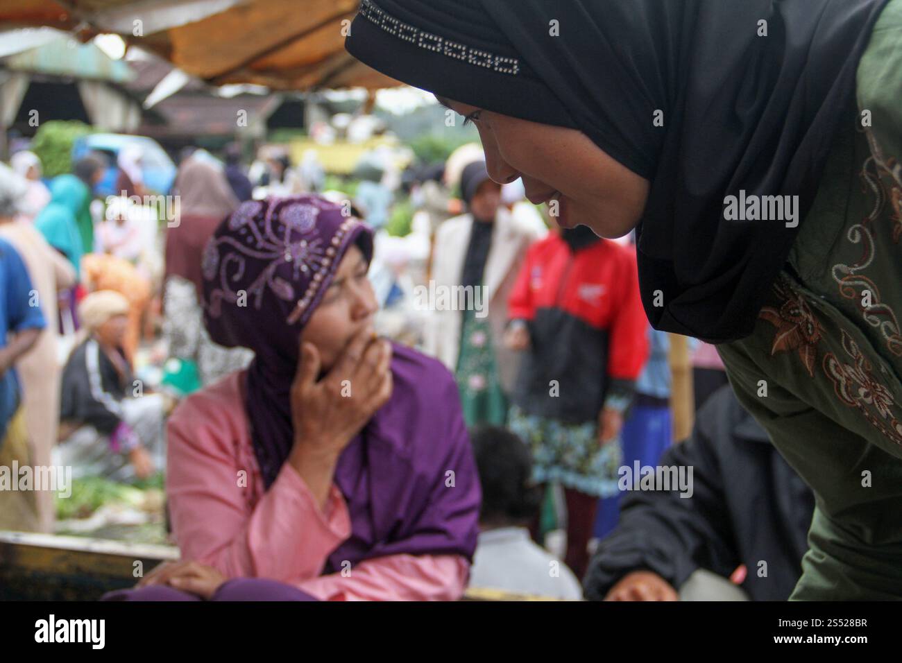 An Indonesian Moslem woman wearing a purple headscarf or hijab and ...
