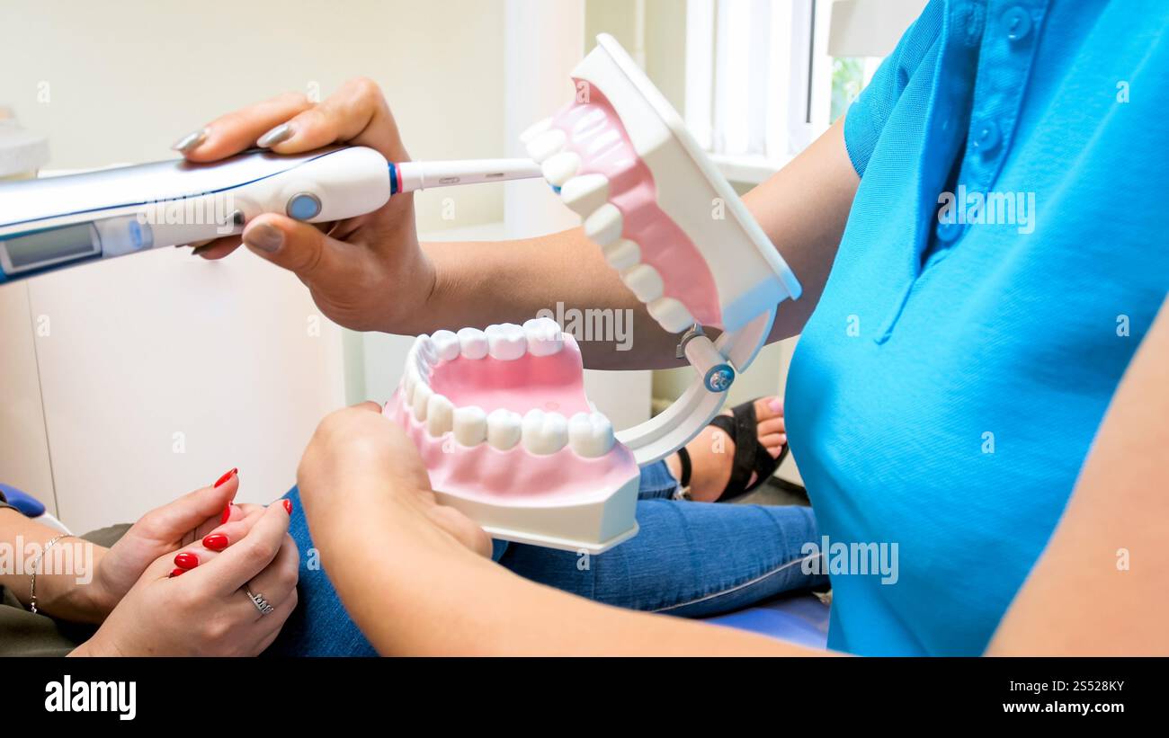 Closeup image of dentist showing how to take care of teeth with ...