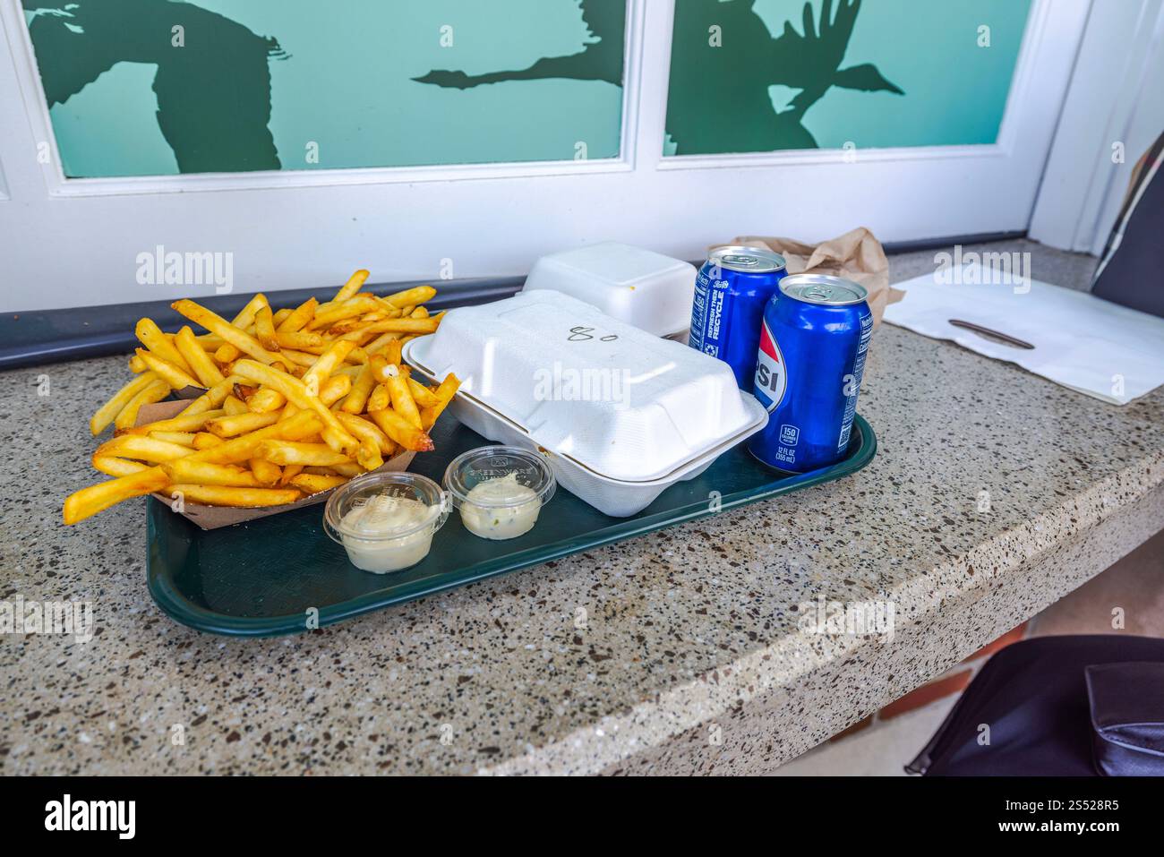 Close-up of tray with French fries, white takeout boxes, sauces and ...