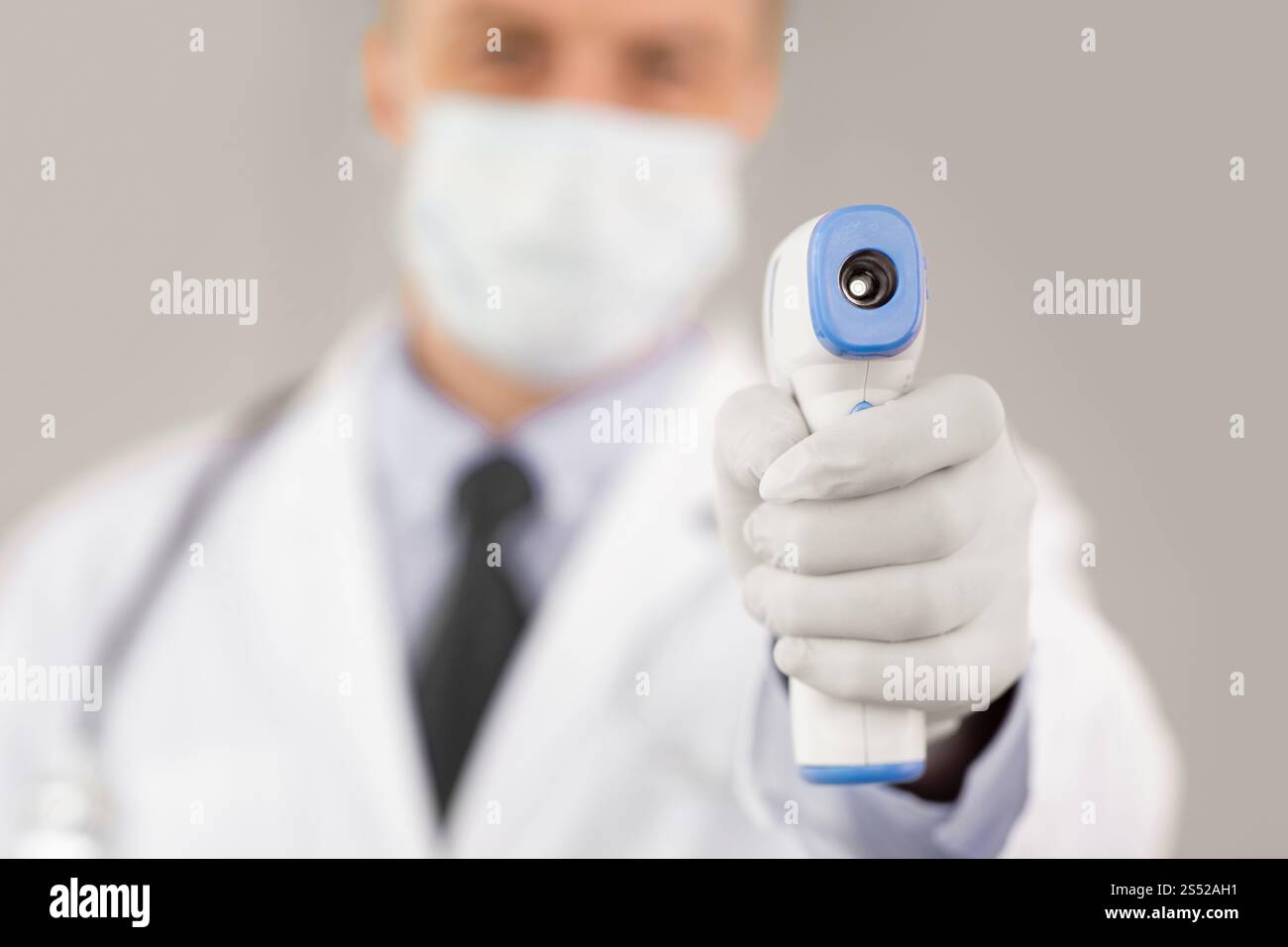 Doctor checking temperature using infrared thermometer gun Stock Photo ...