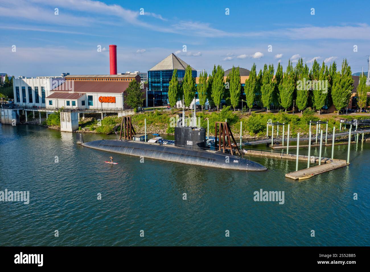 Submarine Docked by Waterfront Under a Clear Blue Sky and Modern Bridge ...