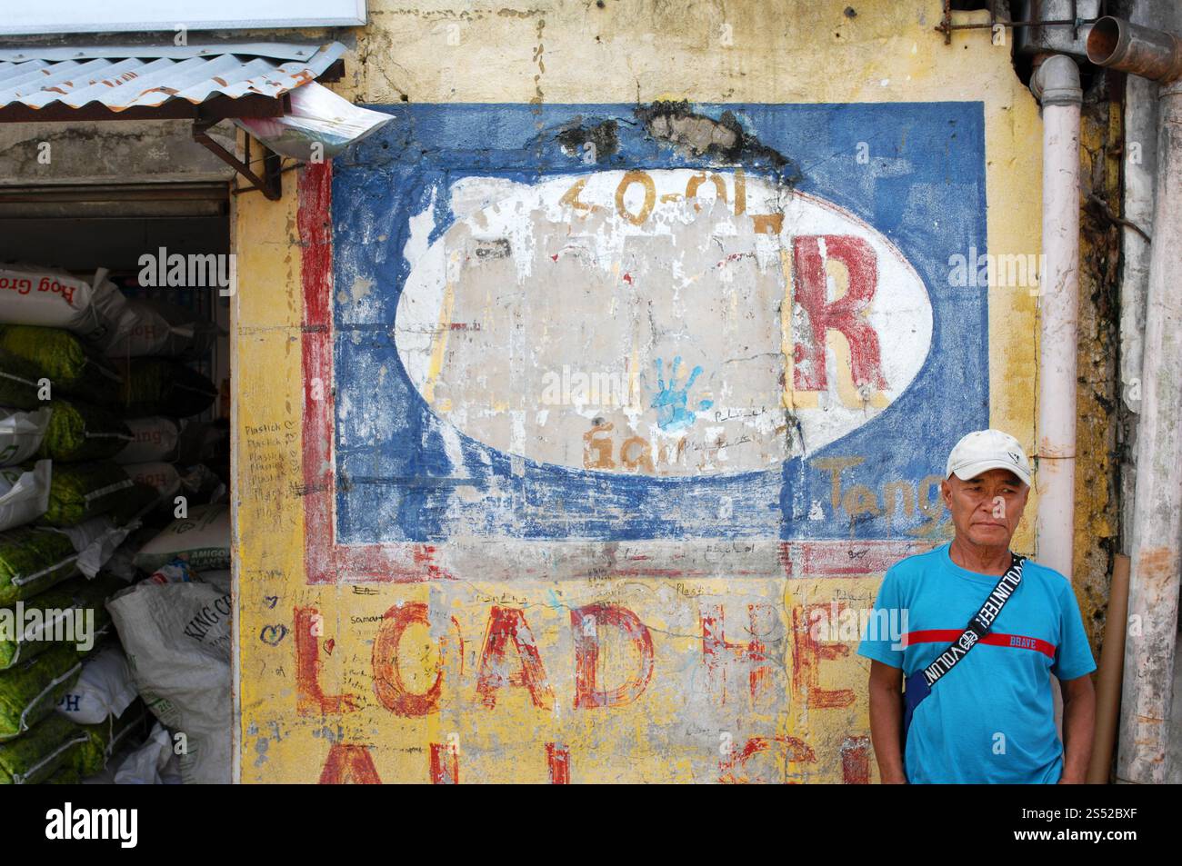 Old man standing next to load here sign, Cadiz City, Negros Occidental ...