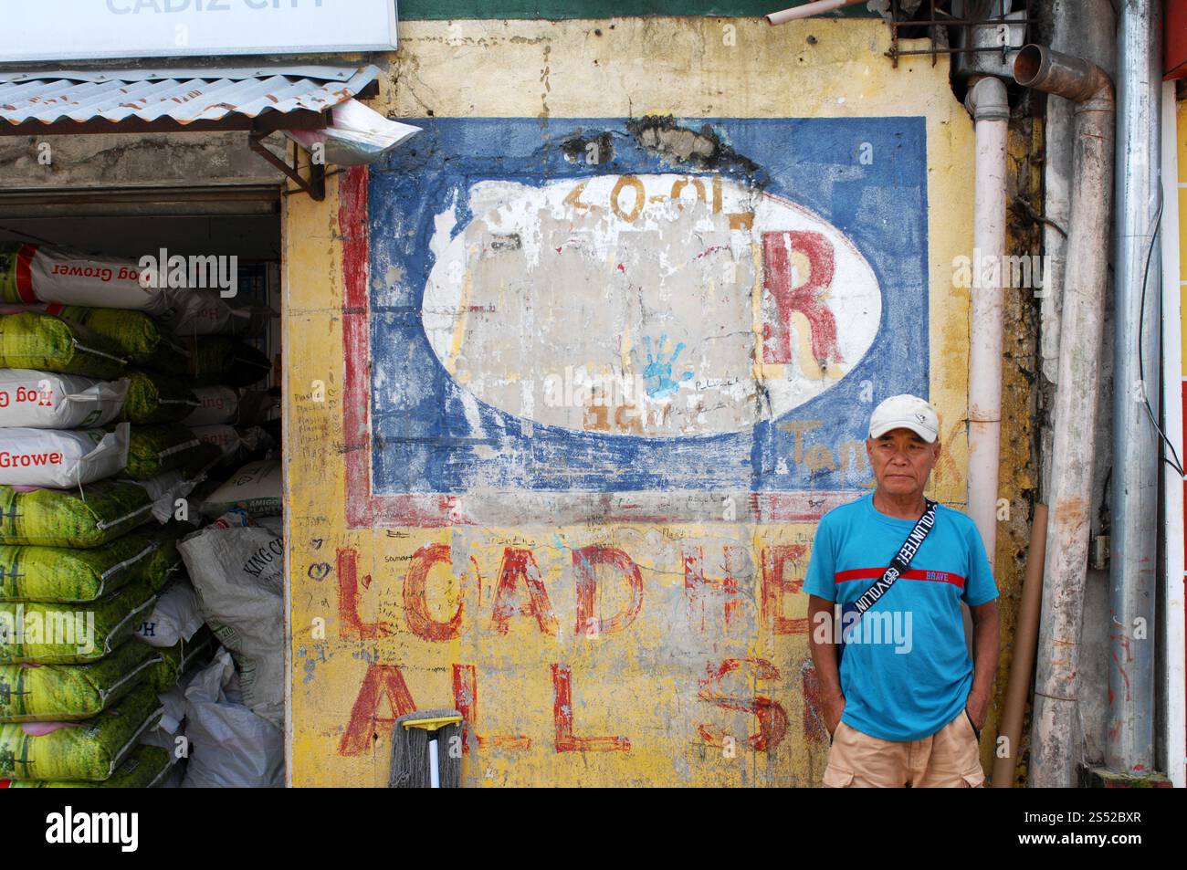 Old man standing next to load here sign, Cadiz City, Negros Occidental ...