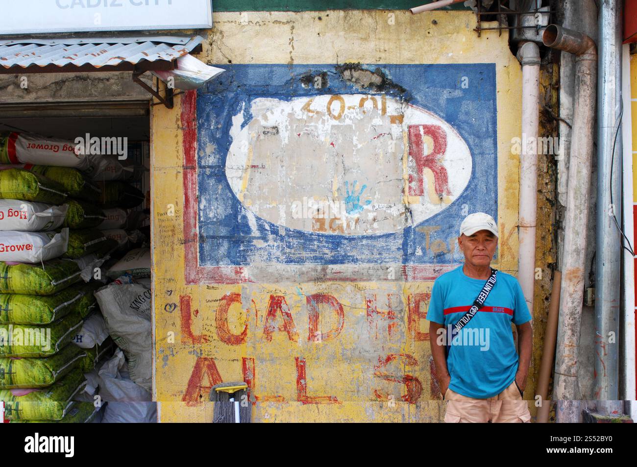 Old man standing next to load here sign, Cadiz City, Negros Occidental, Philippines Stock Photo ...