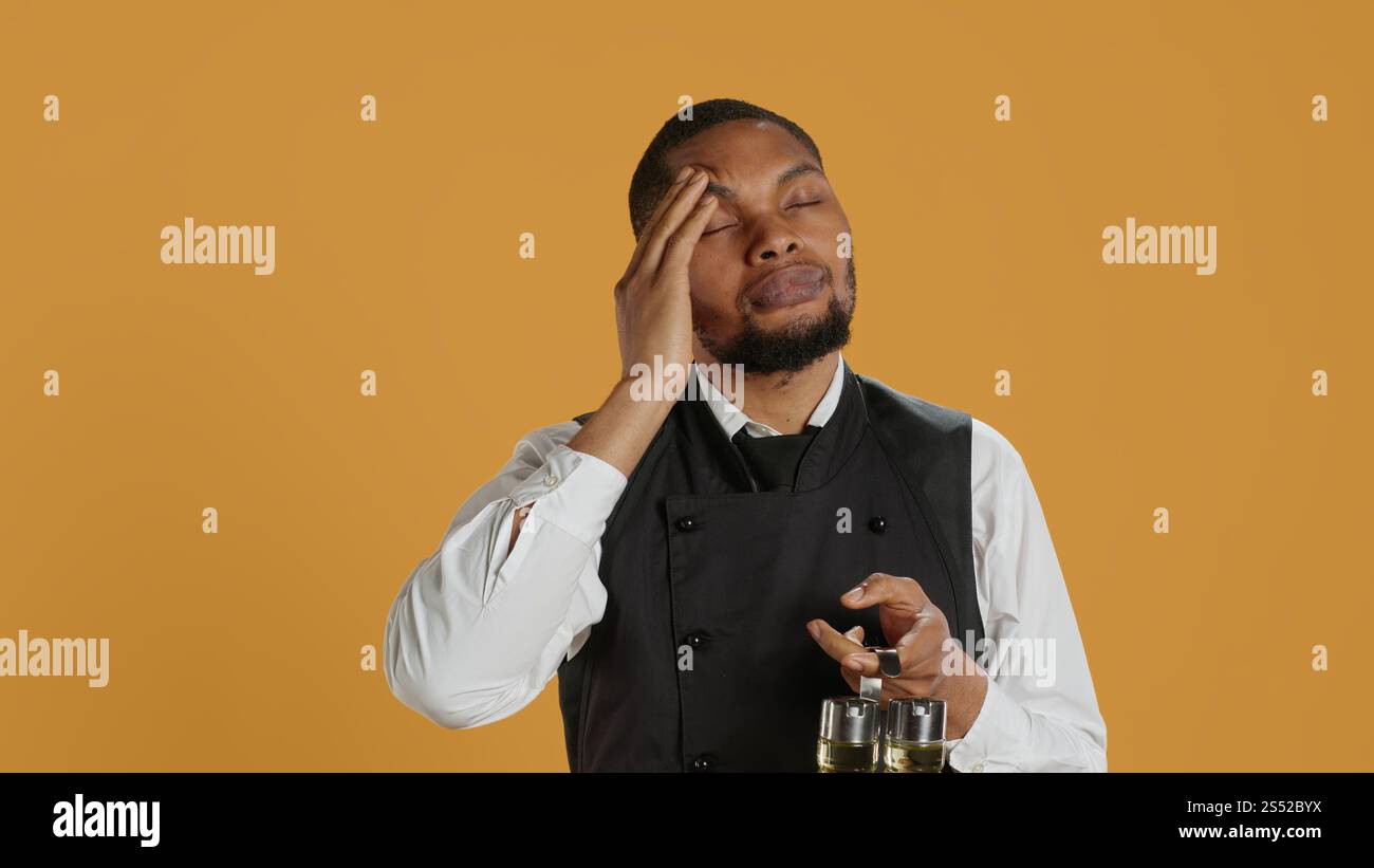 Restaurant employee dealing with a painful headache while he serves ...