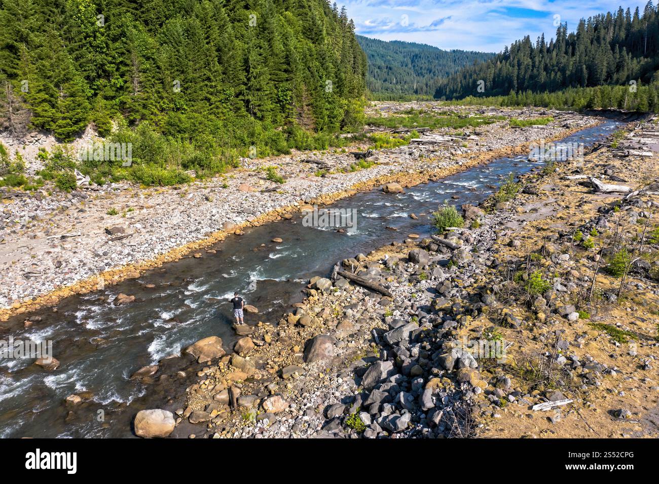 Scenic River With Surrounding Forest and Man Exploring the Natural ...