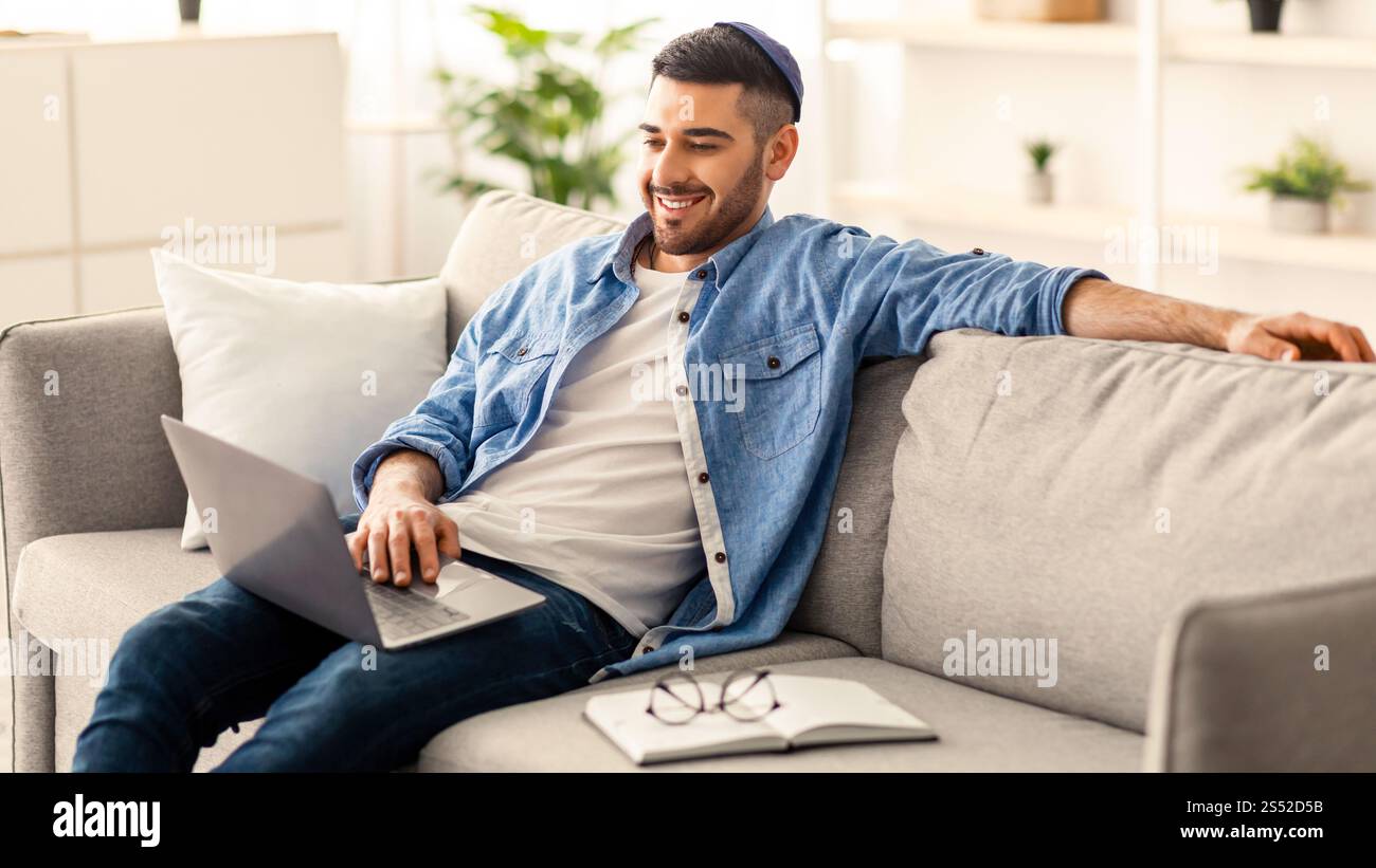 Smiling jewish man watching video on computer Stock Photo - Alamy