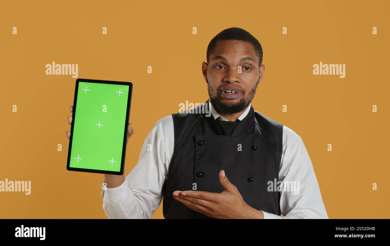 Restaurant waiter presenting a green screen layout on tablet against ...