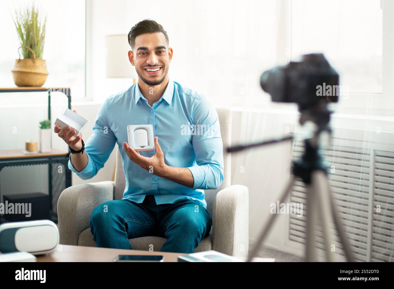 Arab guy vlogger making video review of new wireless earphones, using ...