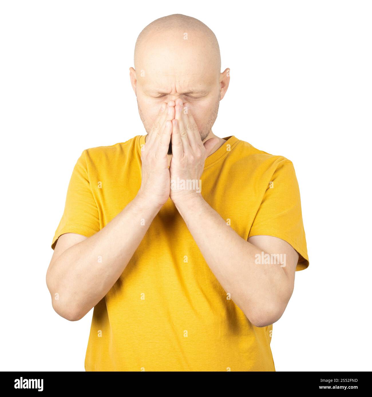 A bald man with a short beard wearing a yellow t-shirt poses against a ...