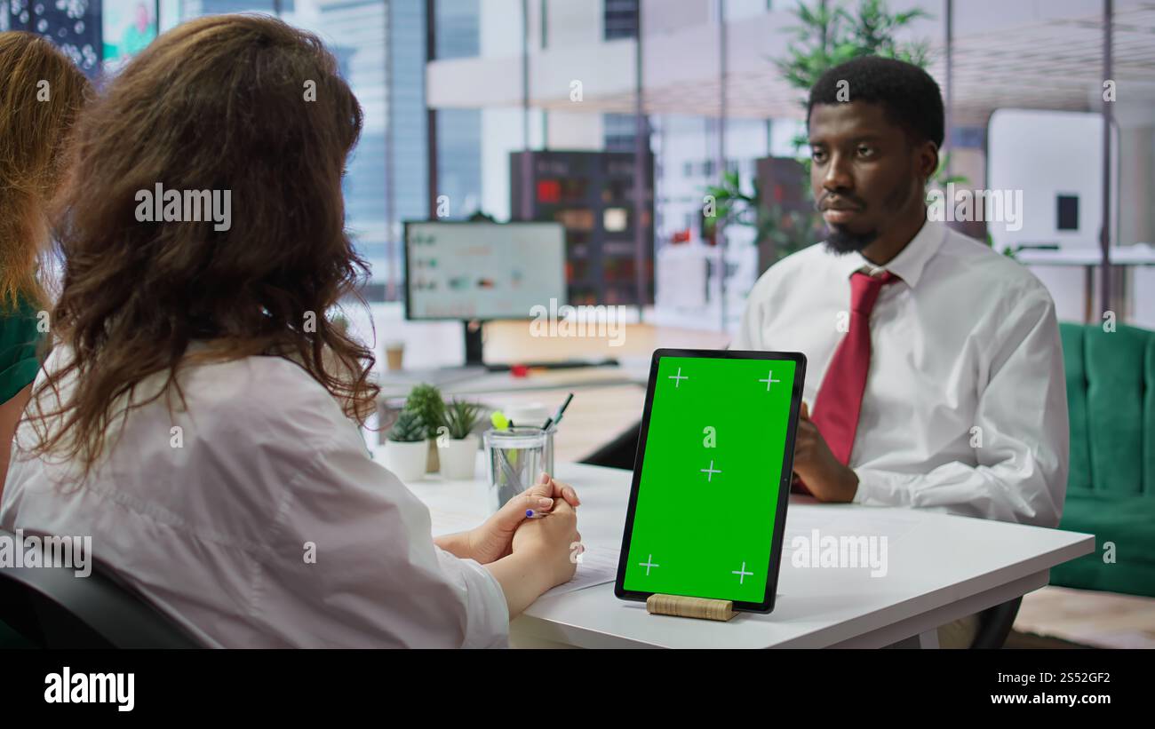 Interviewer and candidate meeting for an interview next to green screen ...