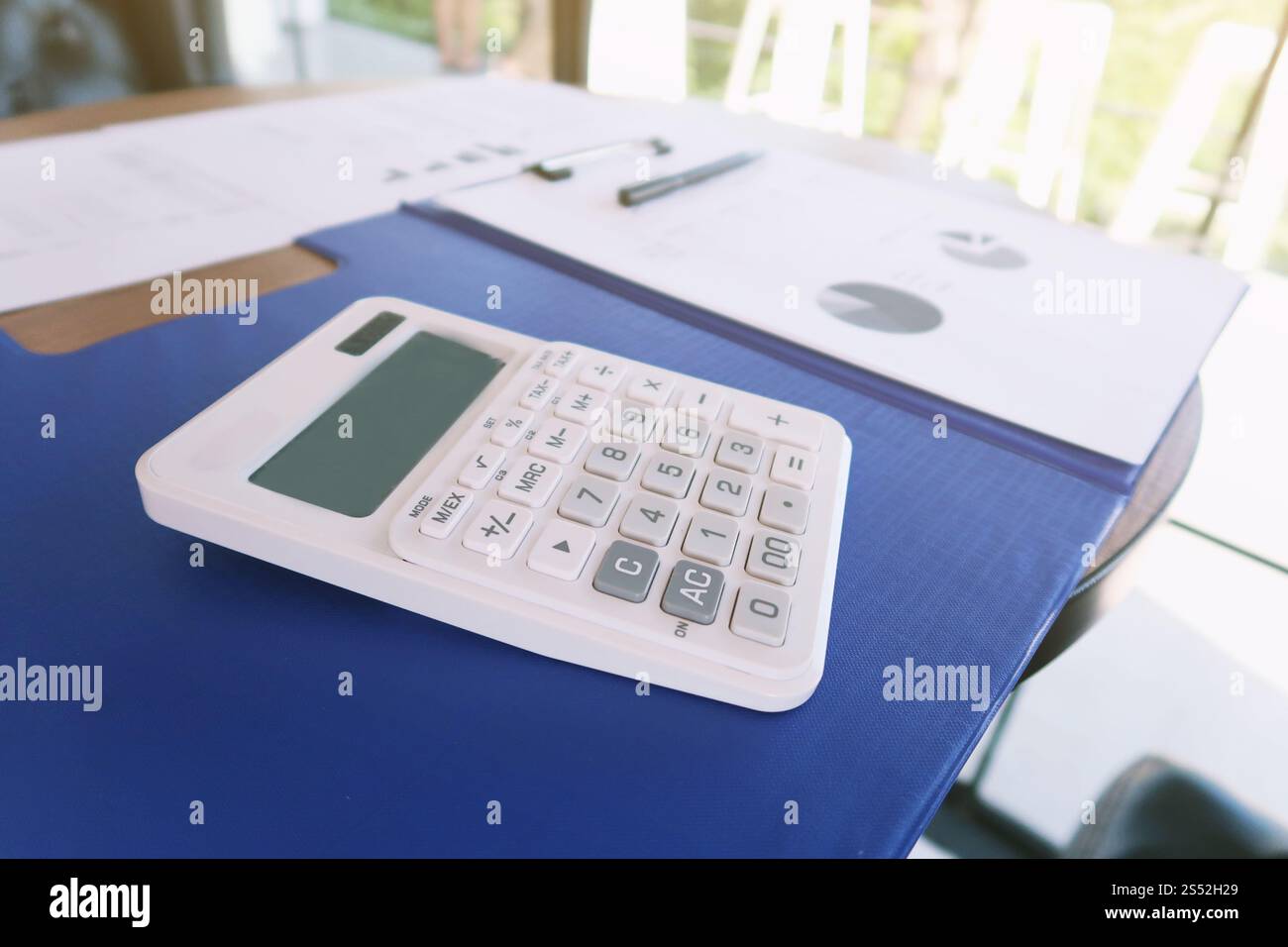 Businesswoman analyzing investment charts and pressing calculator ...